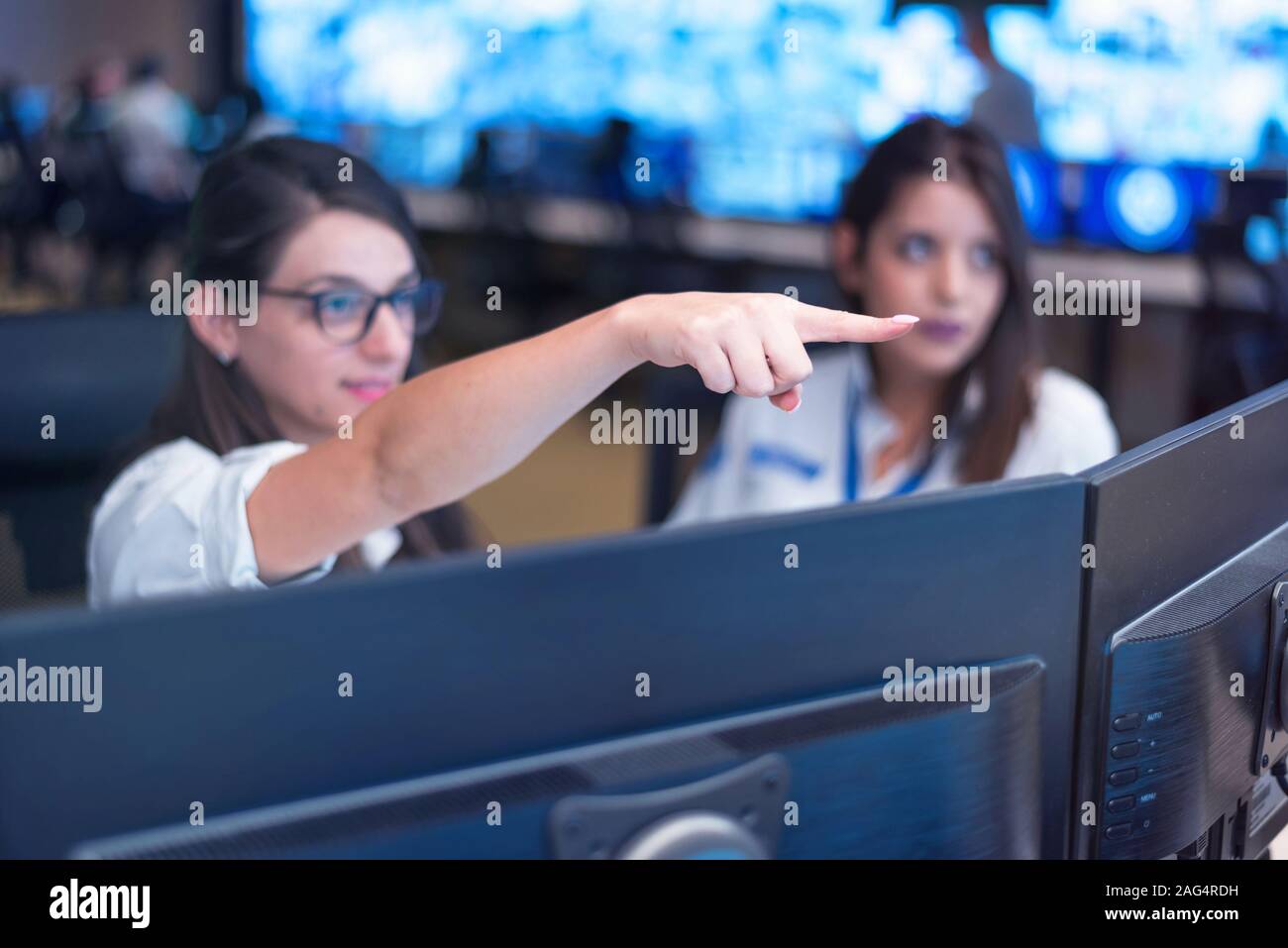 Group of security guards working on computers while sitting in the main ...
