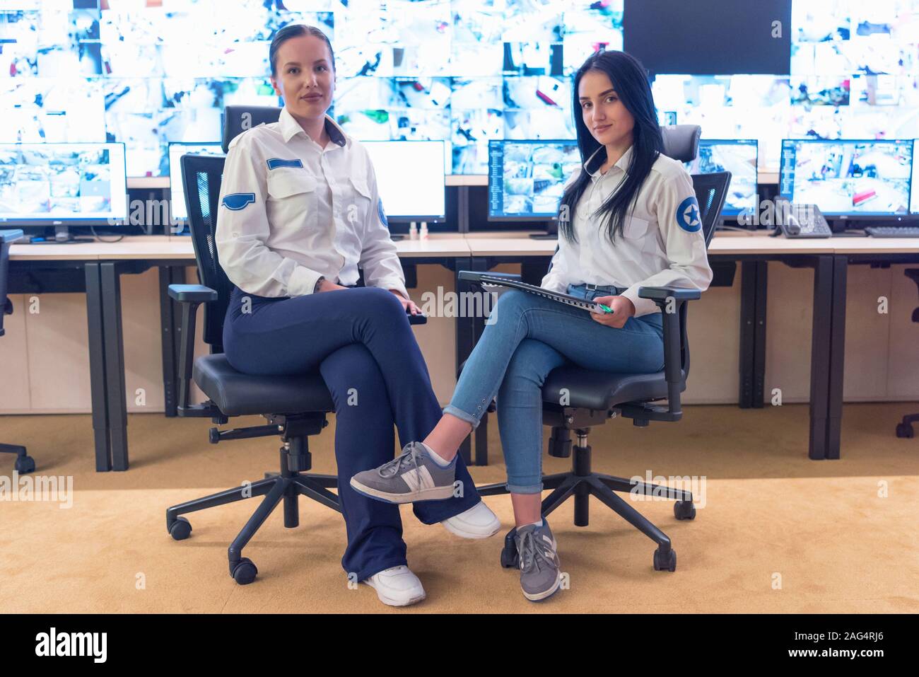 Security guard monitoring modern CCTV cameras in surveillance room. Two ...