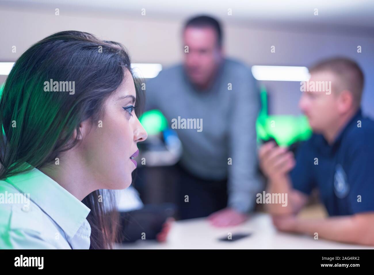 Group of security guards working on computers while sitting in the main ...