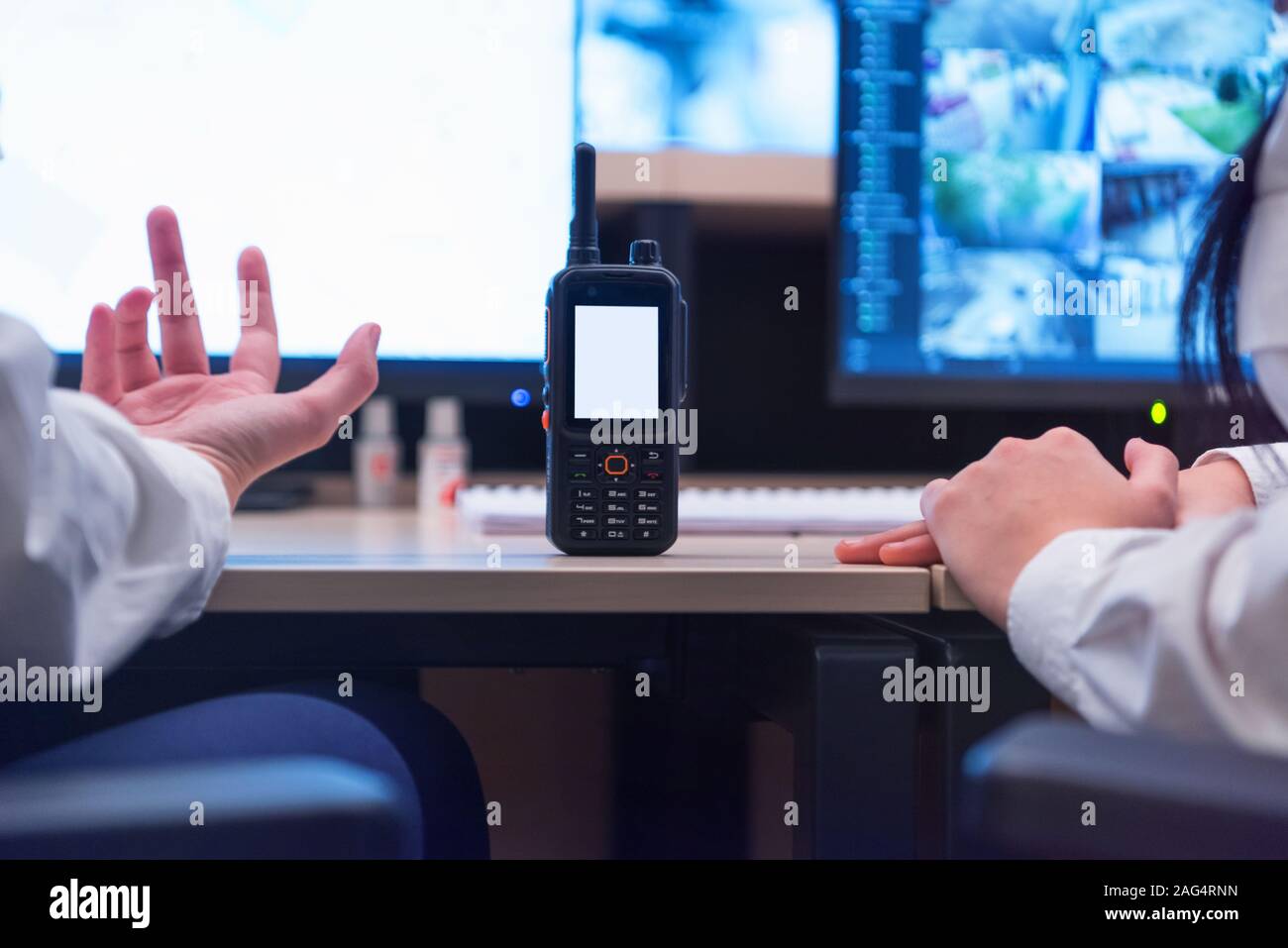 Group of security guards working on computers while sitting in the main ...