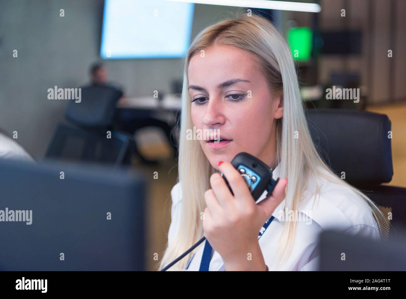 Female security guard operator talking on the phone, calling in the ...