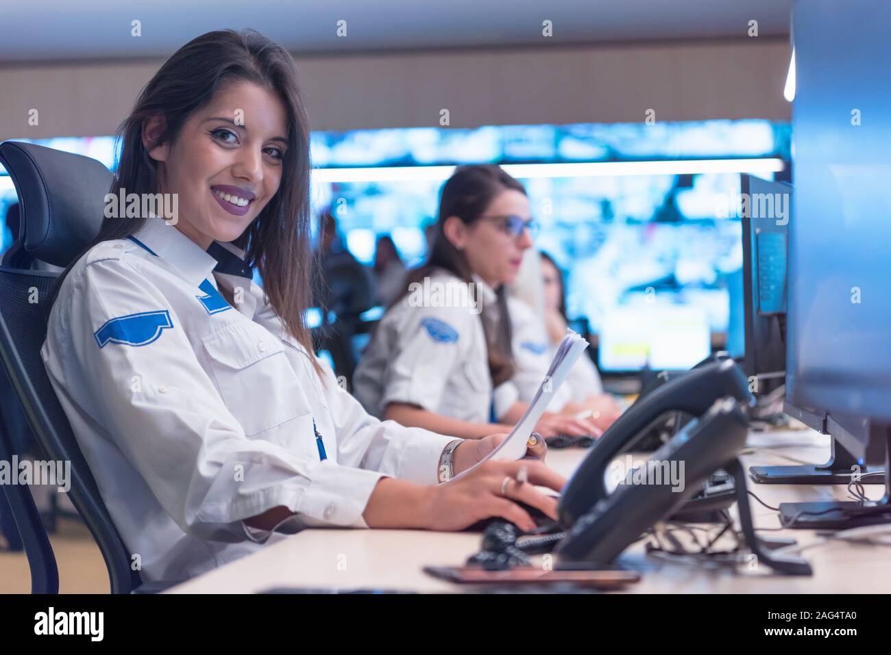 Group of security guards working on computers while sitting in the main ...