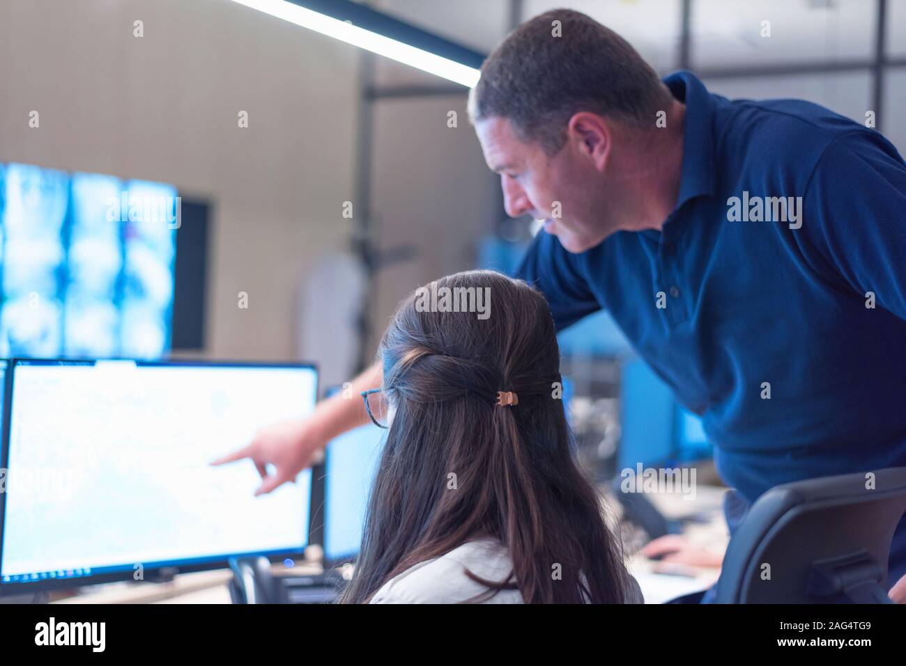 Group of security guards working on computers while sitting in the main ...