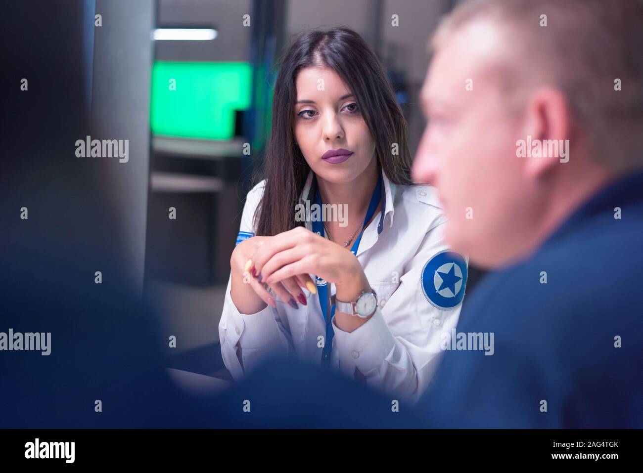 Group of security guards working on computers while sitting in the main ...