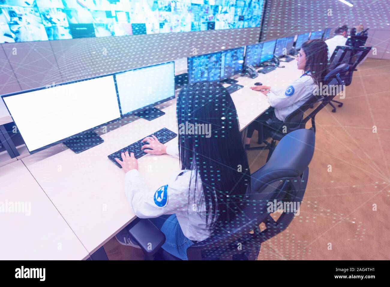 Group of security guards working on computers while sitting in the main ...