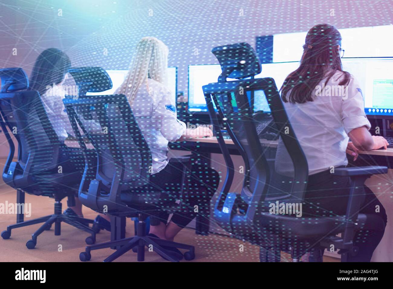 Group of security guards working on computers while sitting in the main ...