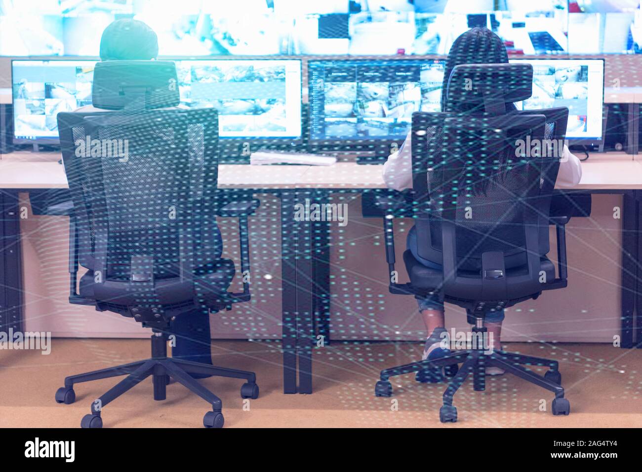 Group of security guards working on computers while sitting in the main ...
