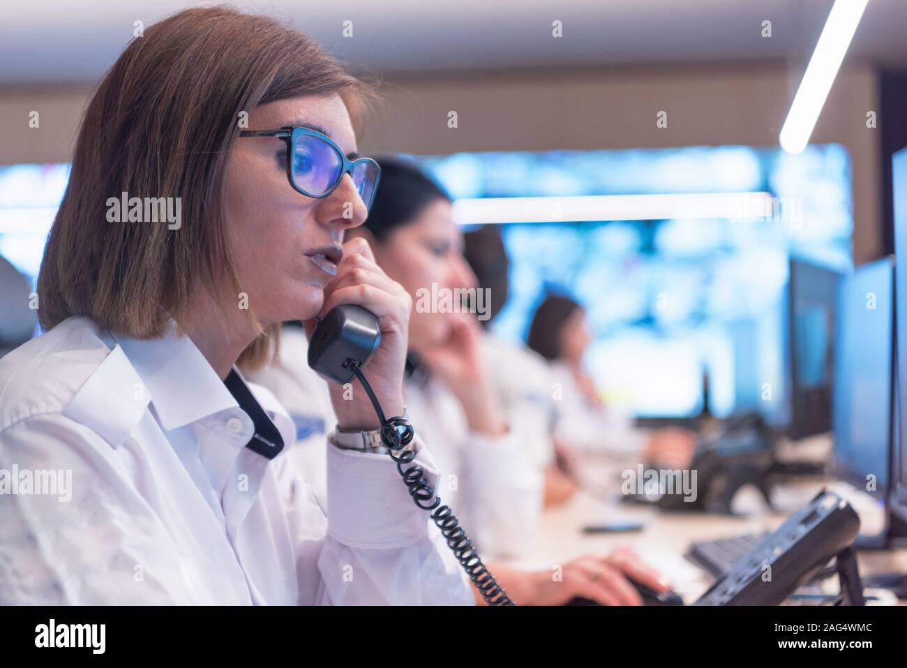 Female security guard operator talking on the phone, calling in the ...