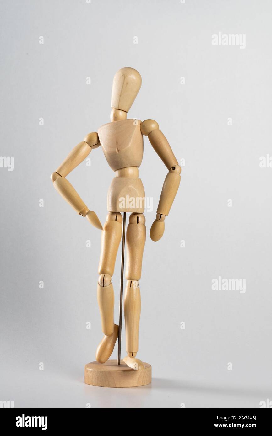 Vertical shot of a wooden pose doll with its hands on its waist with a ...