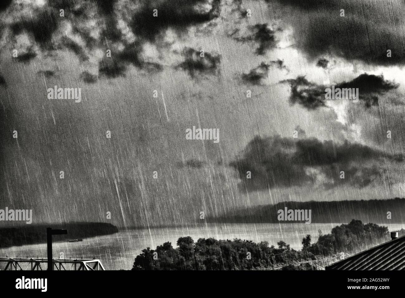 Grayscale shot of pouring rain over a lake - depression, loneliness ...