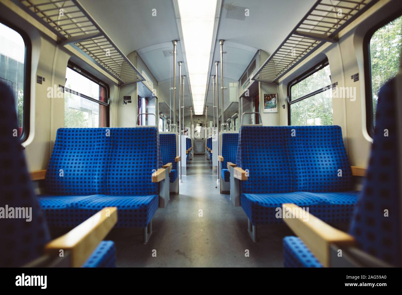 Shot of the interior of the inside of an empty train with blue seats ...
