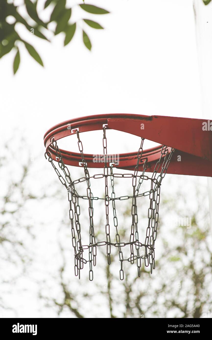 Vertical closeup shot of a basketball hoop with a bright background ...