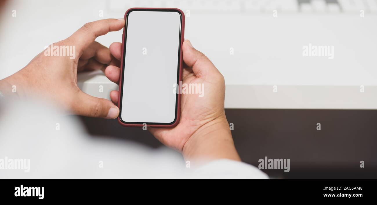 Cropped shot of young businessman holding blank screen smartphone while ...