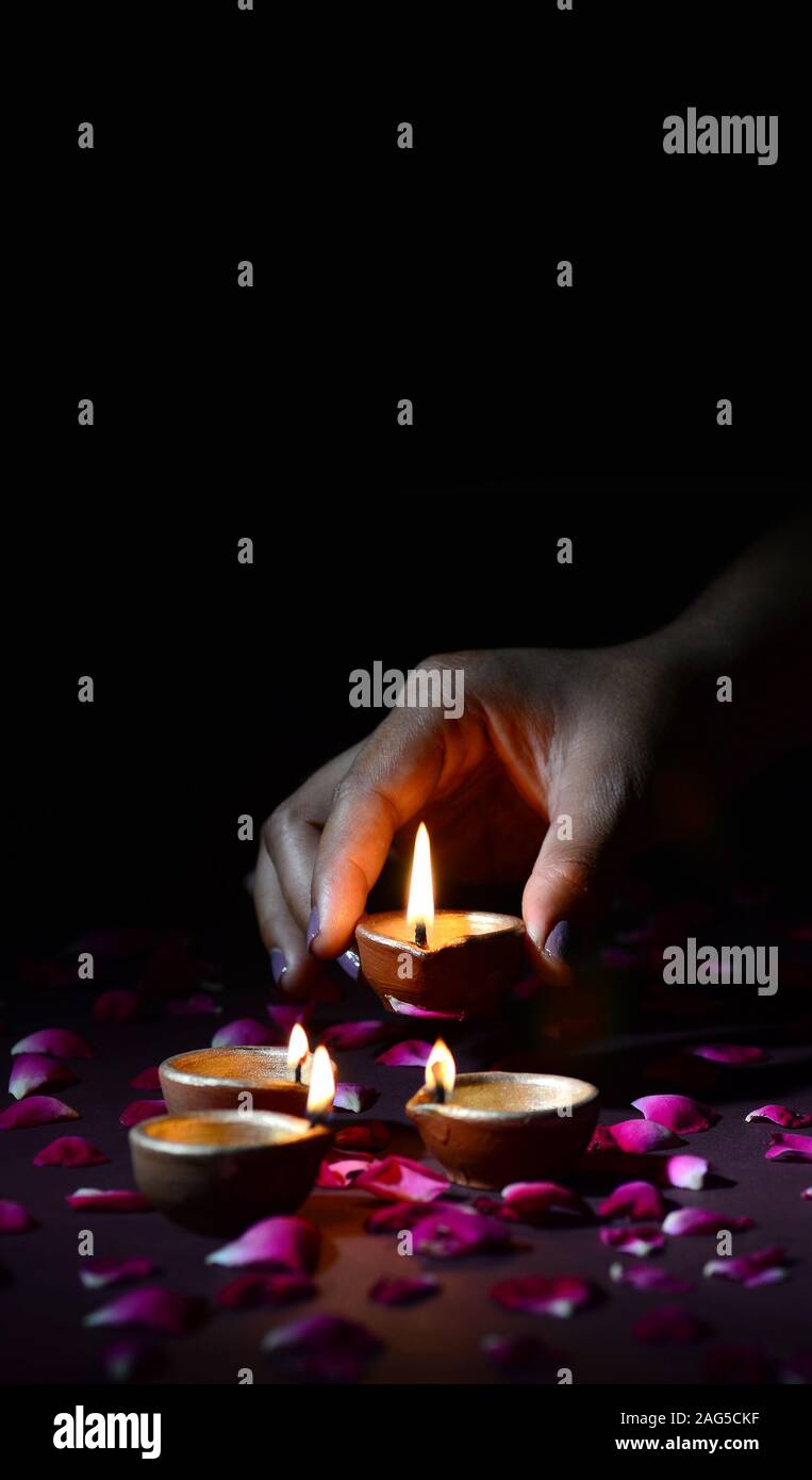 Hand holding and arranging lantern (Diya) during Diwali Festival of ...