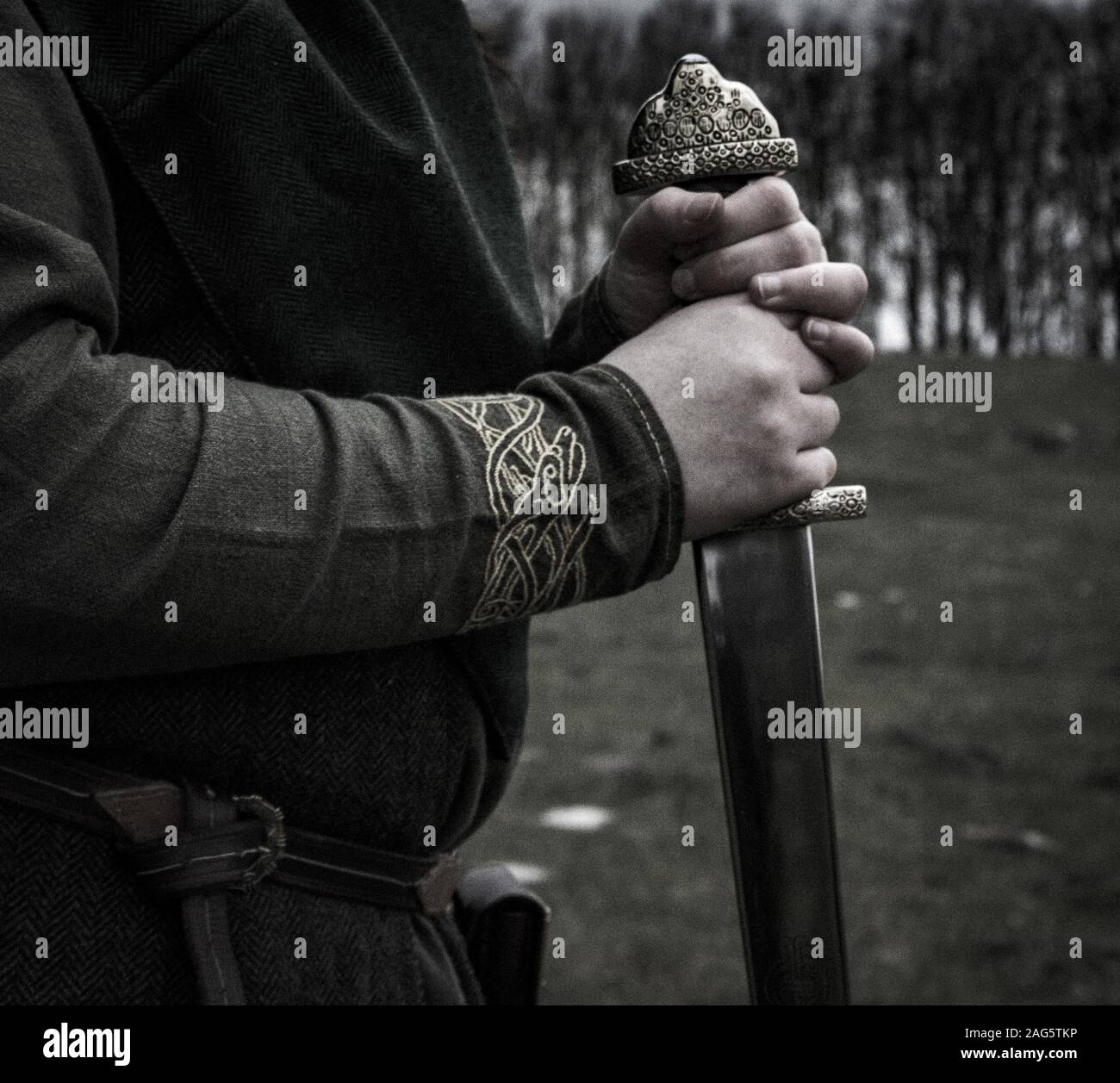 Warrior wearing national traditional clothes holding a sword standing ...