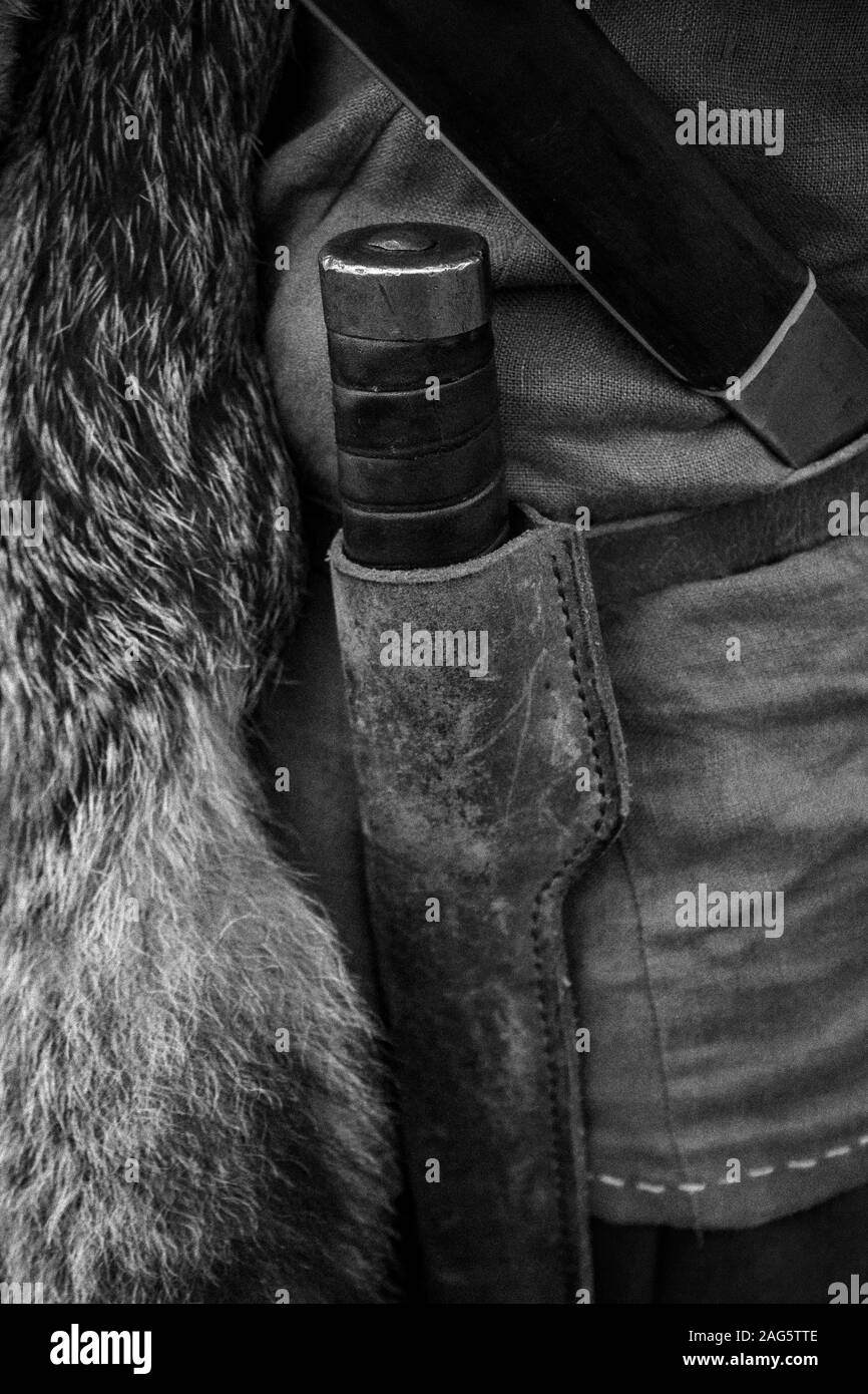 Vertical grayscale shot of a Viking warrior with a dagger in the case ...