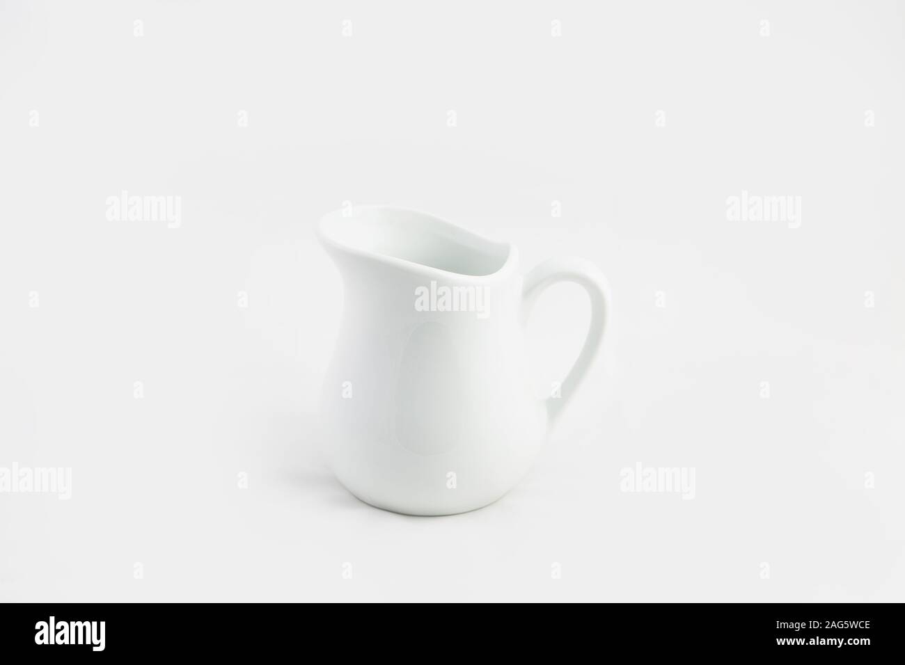 Closeup shot of a white ceramic pitcher isolated on a white background ...