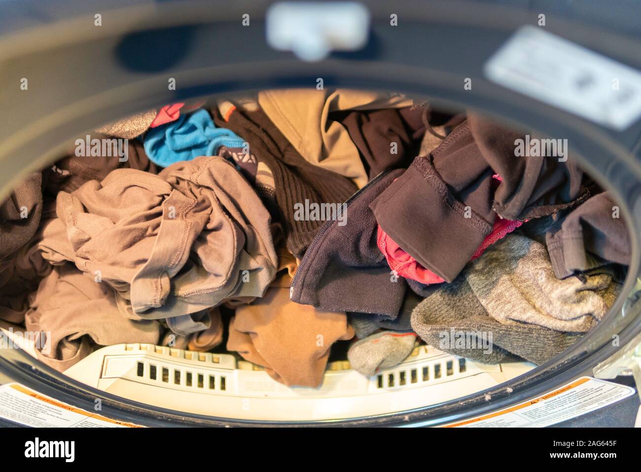 Fresh clean clothes in a dryer after wash Stock Photo - Alamy