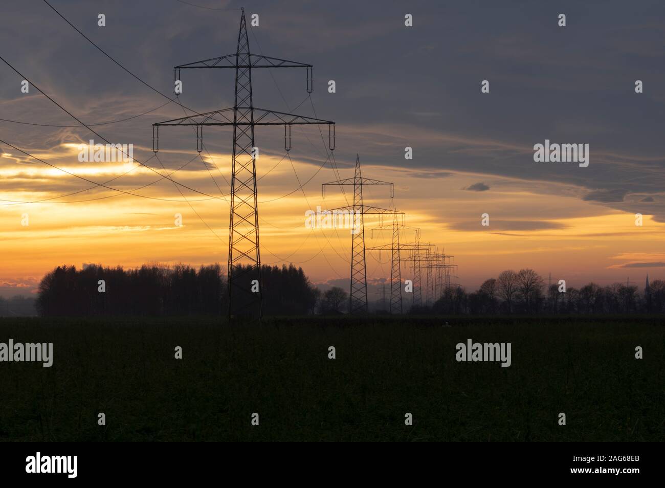 electricity pylons power line at orange sunset Stock Photo - Alamy