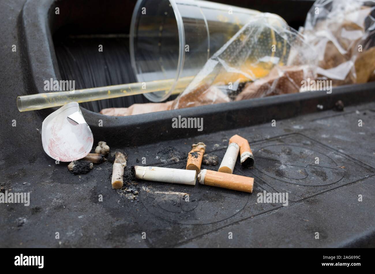 Discarded burnt cigarettes and litter on rubbish bin lid Stock Photo ...