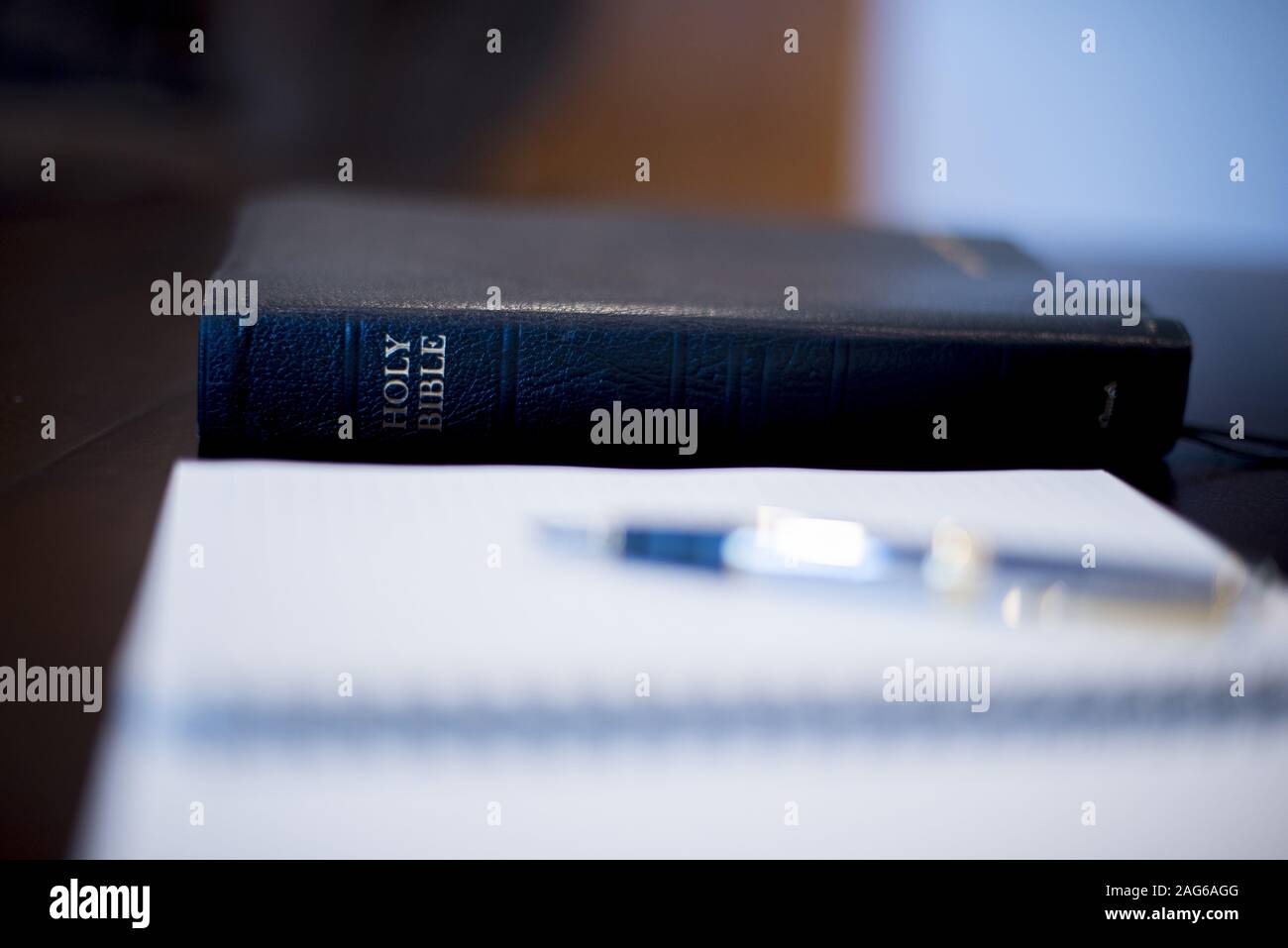 Selective focus shot of the holy bible on a wooden table with a blurred ...