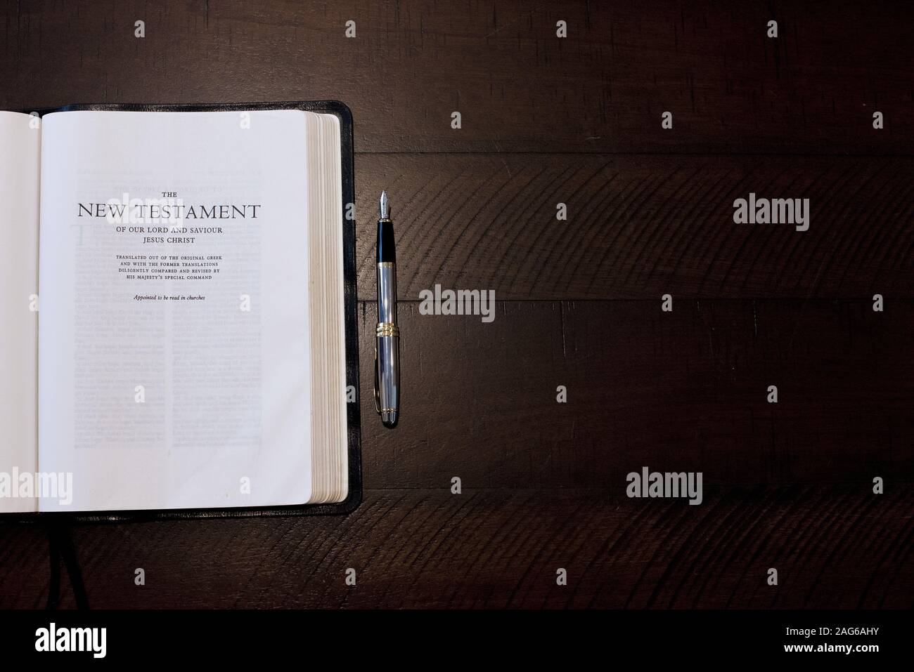 Overhead shot of an open bible near a pen on a wooden surface Stock ...
