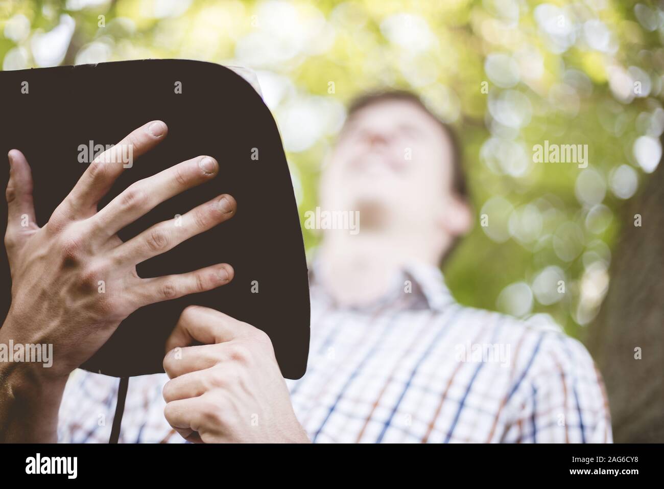 Low angle shot of a male holding an open bible with a blurred ...