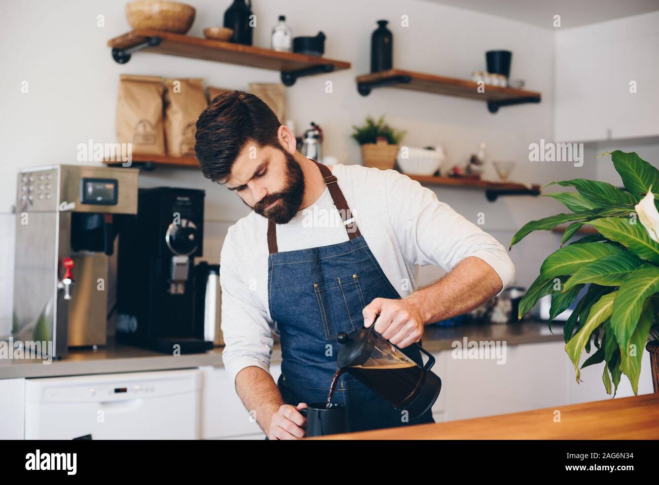COSTA MESA, UNITED STATES - Jan 03, 2019: Male barista making coffee ...
