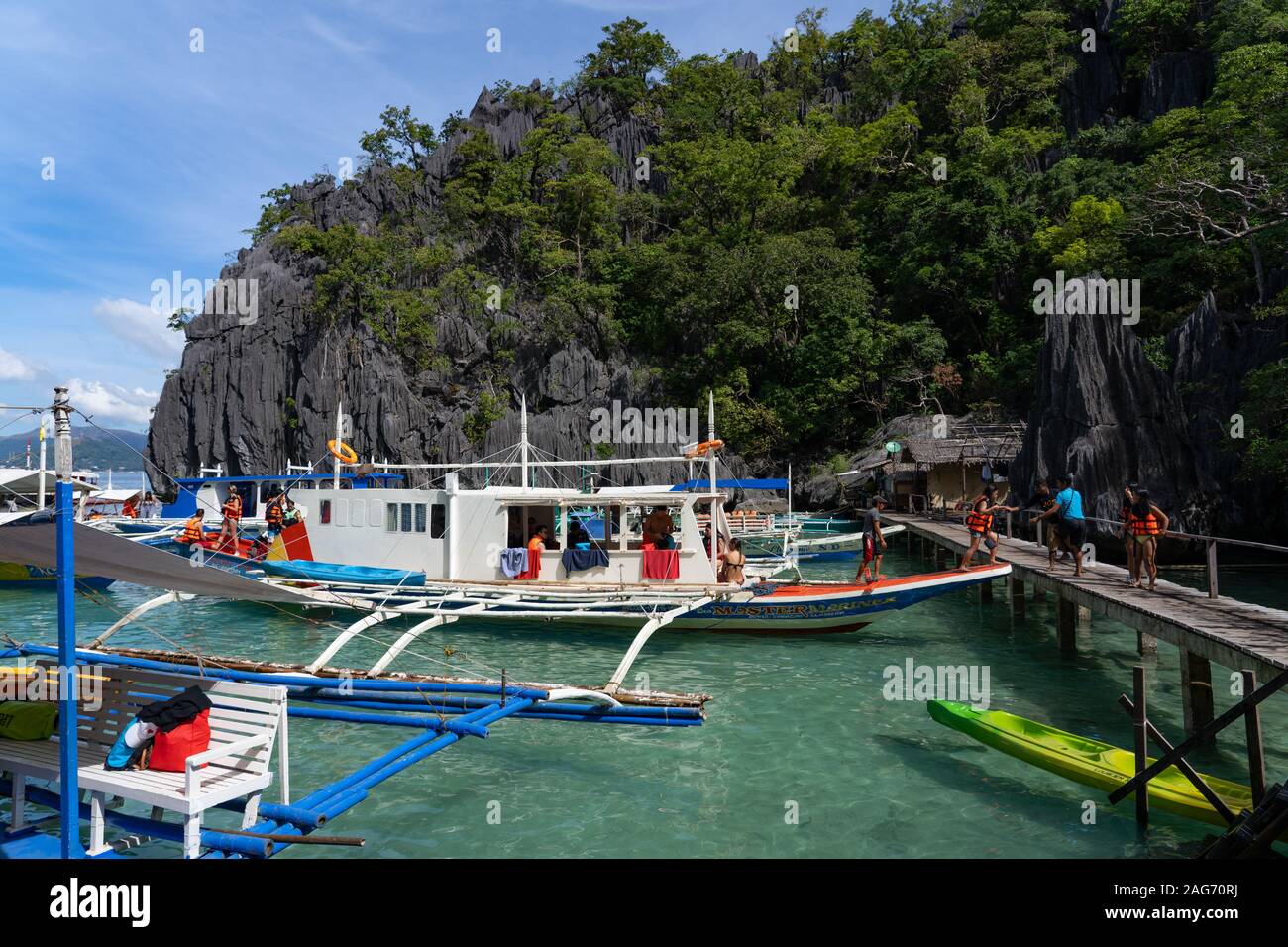 Day trippers disembarking a traditional outrigger boat used on Island ...