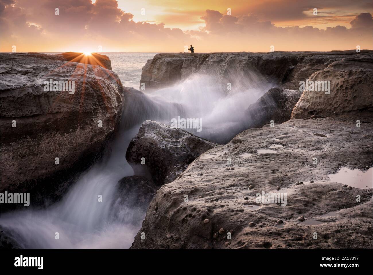 Breathtaking shot of huge stones in the ocean with the foamy water ...