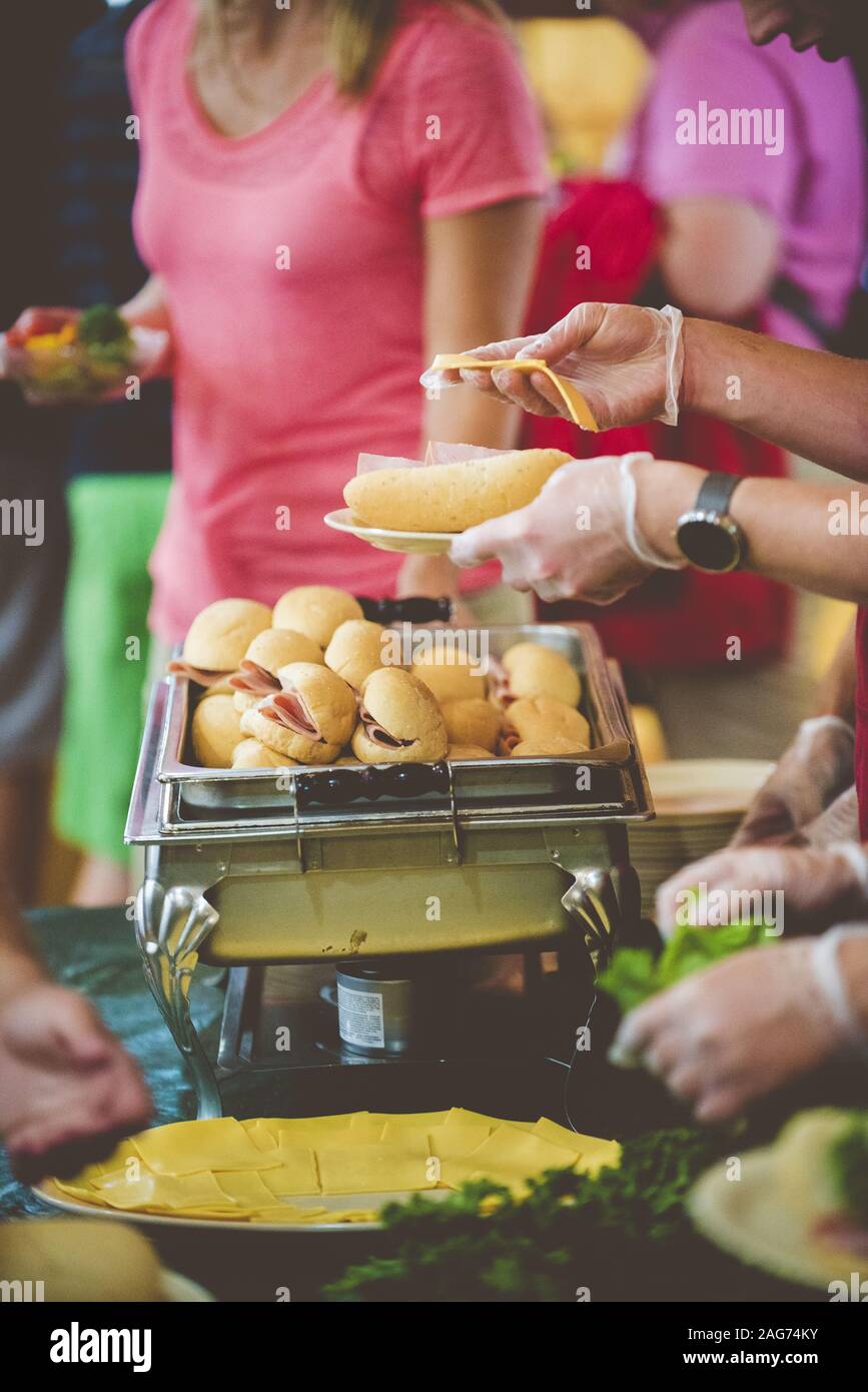 Vertical shot of a person making a sandwich with a blurred background ...