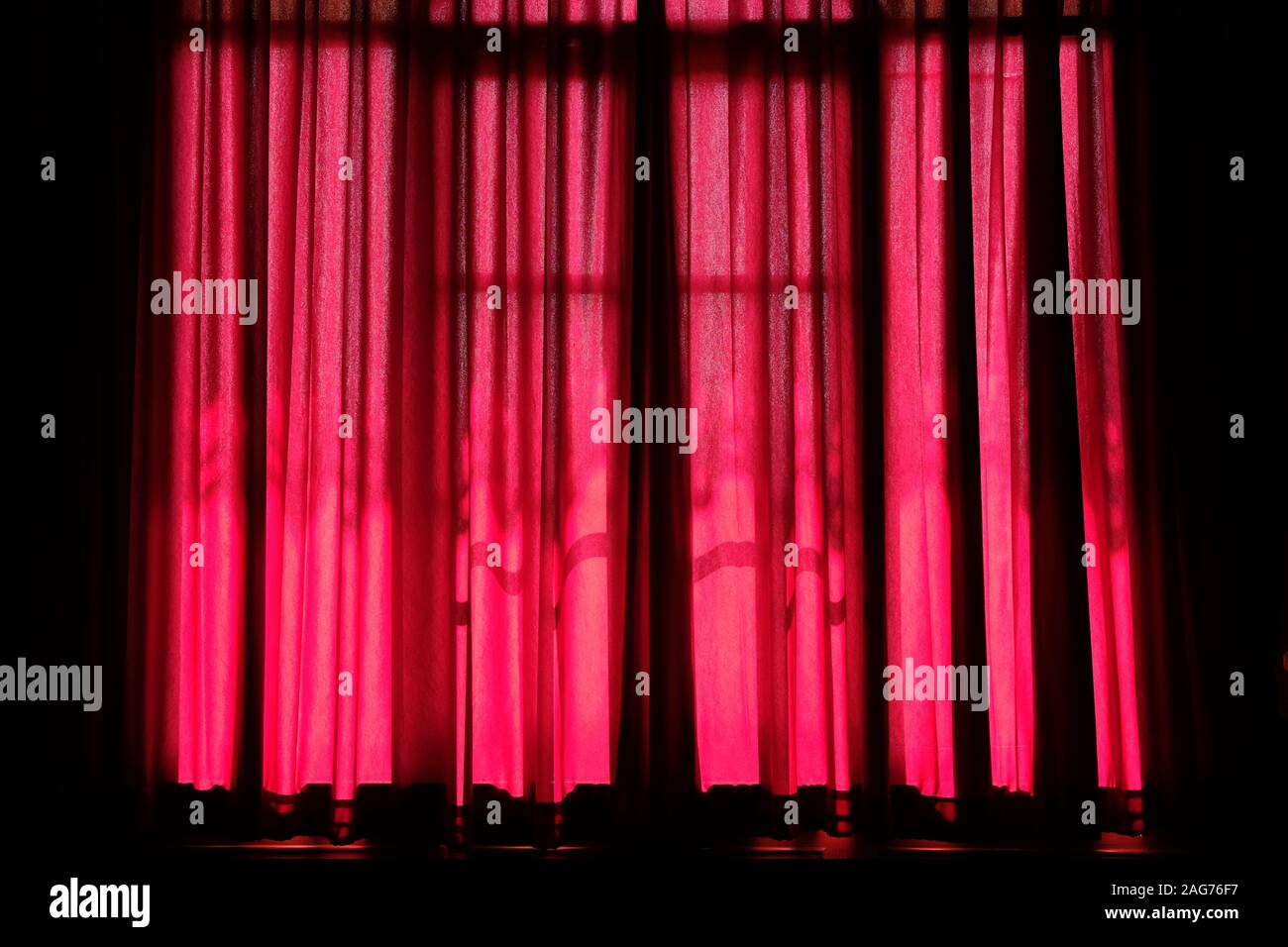 sunlight on red curtain. fabric folds in residential home interior ...