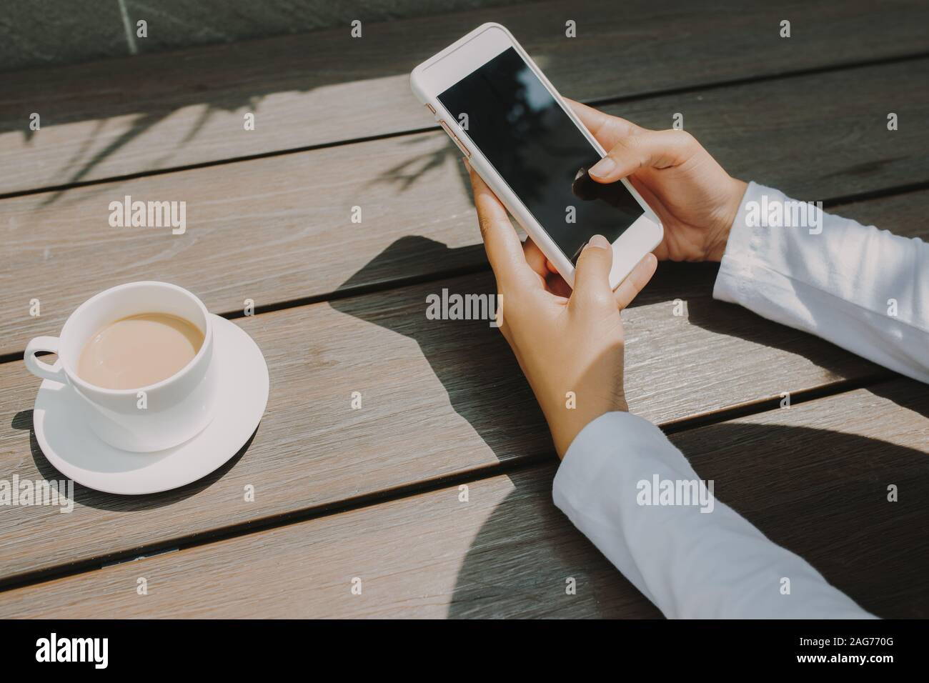 Woman hand texting for someone with black screen at coffee shop Stock ...