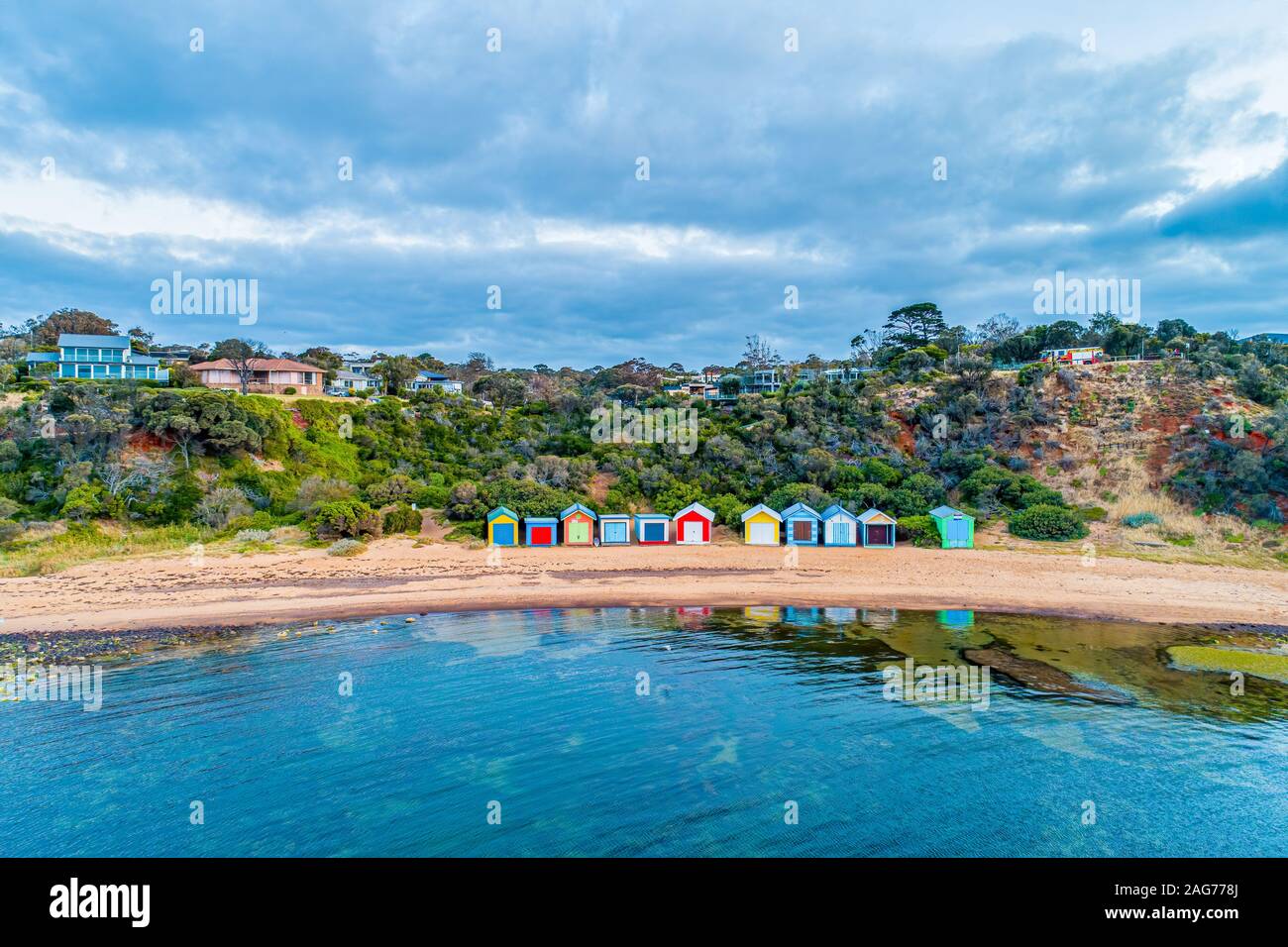 Colorful bathing boxes with reflections on ocean beach in Melbourne ...