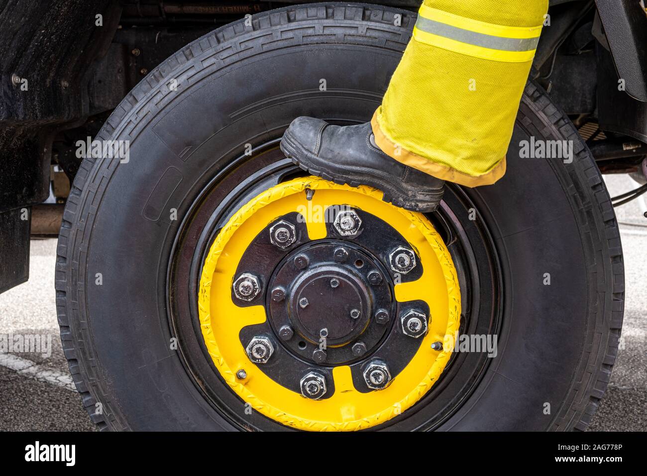Fireman boot standing on large wheel of fire engine truck Stock Photo ...