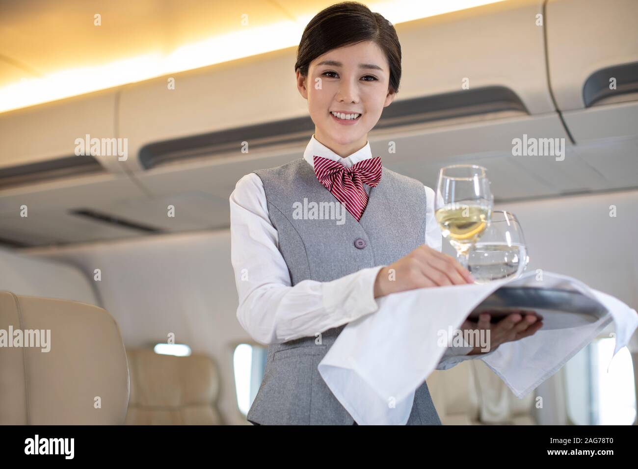 Chinese flight attendant serving wine Stock Photo - Alamy