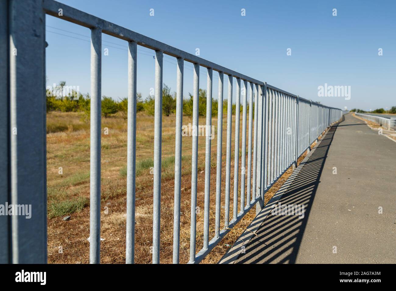 metal fence between the field and the pedestrian walkway, highway Stock ...