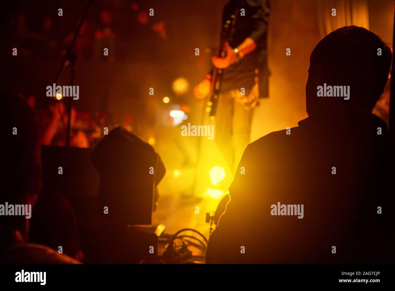 The silhouette of spectator near the stage. Performance of a rock band ...