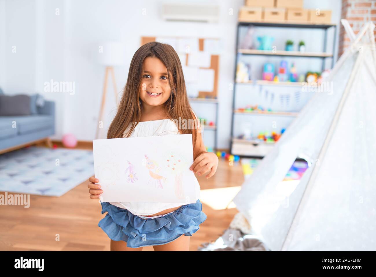 Adorable toddler smiling happy holding nice draw around lots of toys at ...