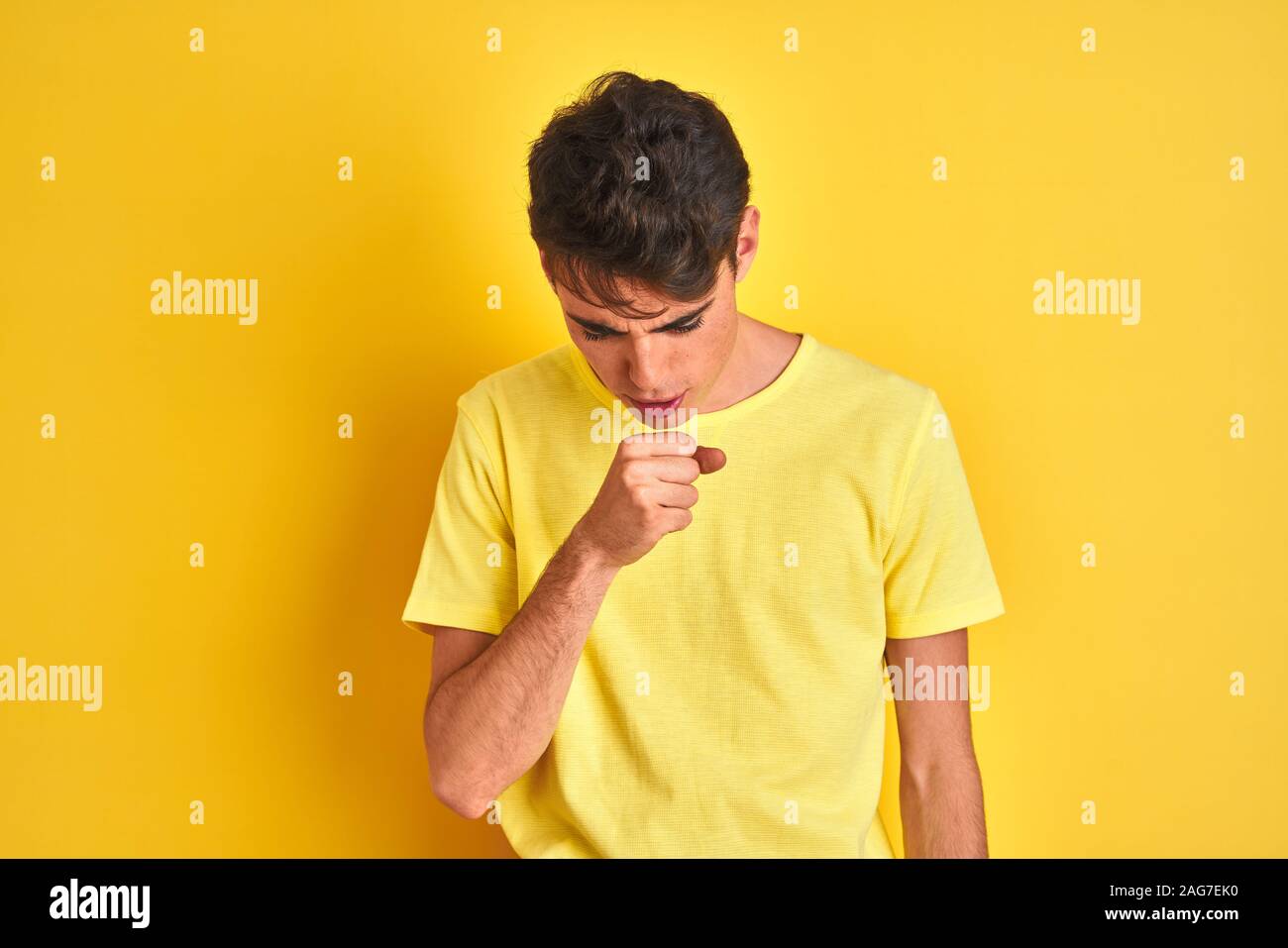 Teenager boy wearing yellow t-shirt over isolated background feeling ...