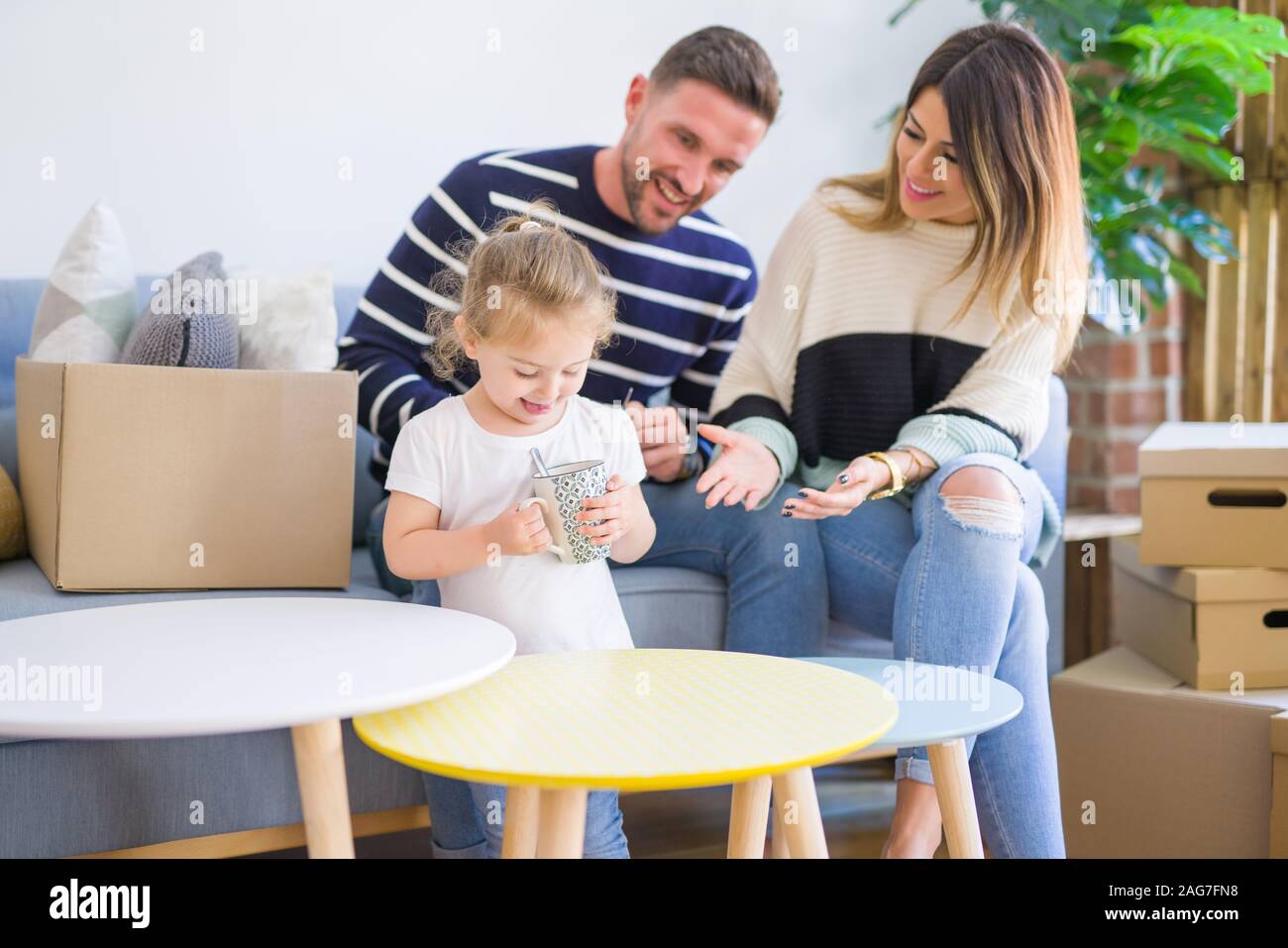 Beautiful family, parents sitting on the sofa drinking coffee looking ...