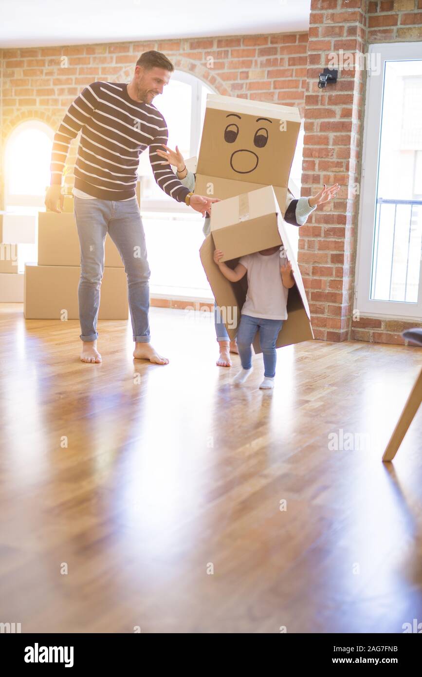 Beautiful famiily with kid playing with cardboard fanny boxes at new ...