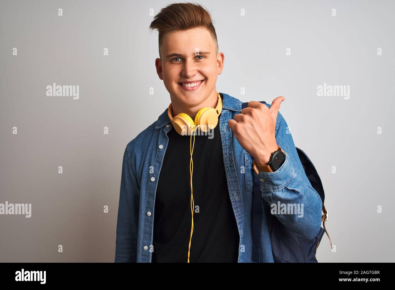 Young student man wearing denim shirt backpack headphones over isolated ...