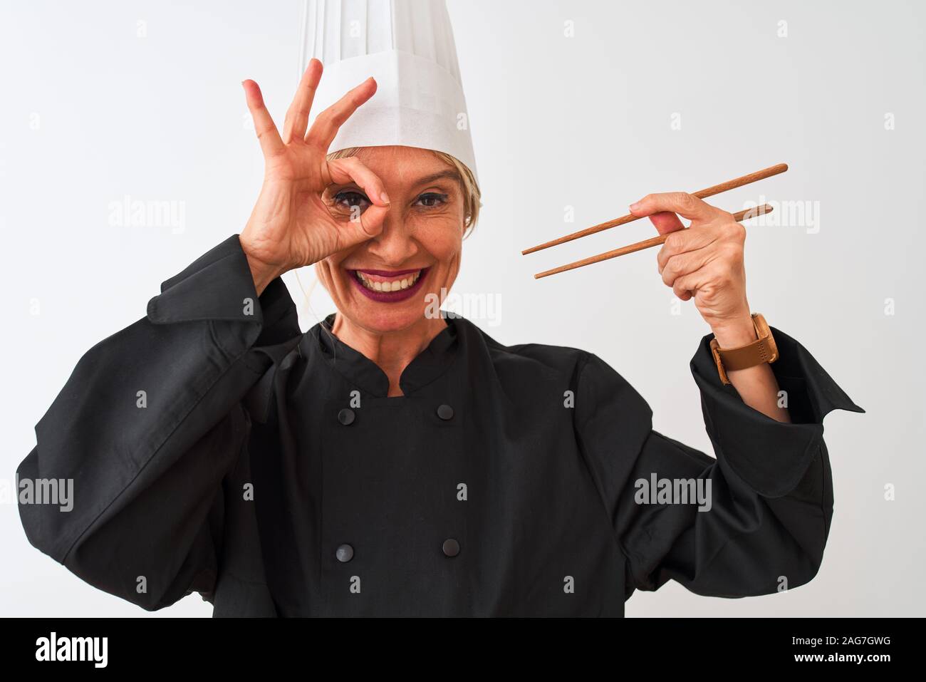 Middle age chef woman wearing cap holding chopsticks over isolated ...