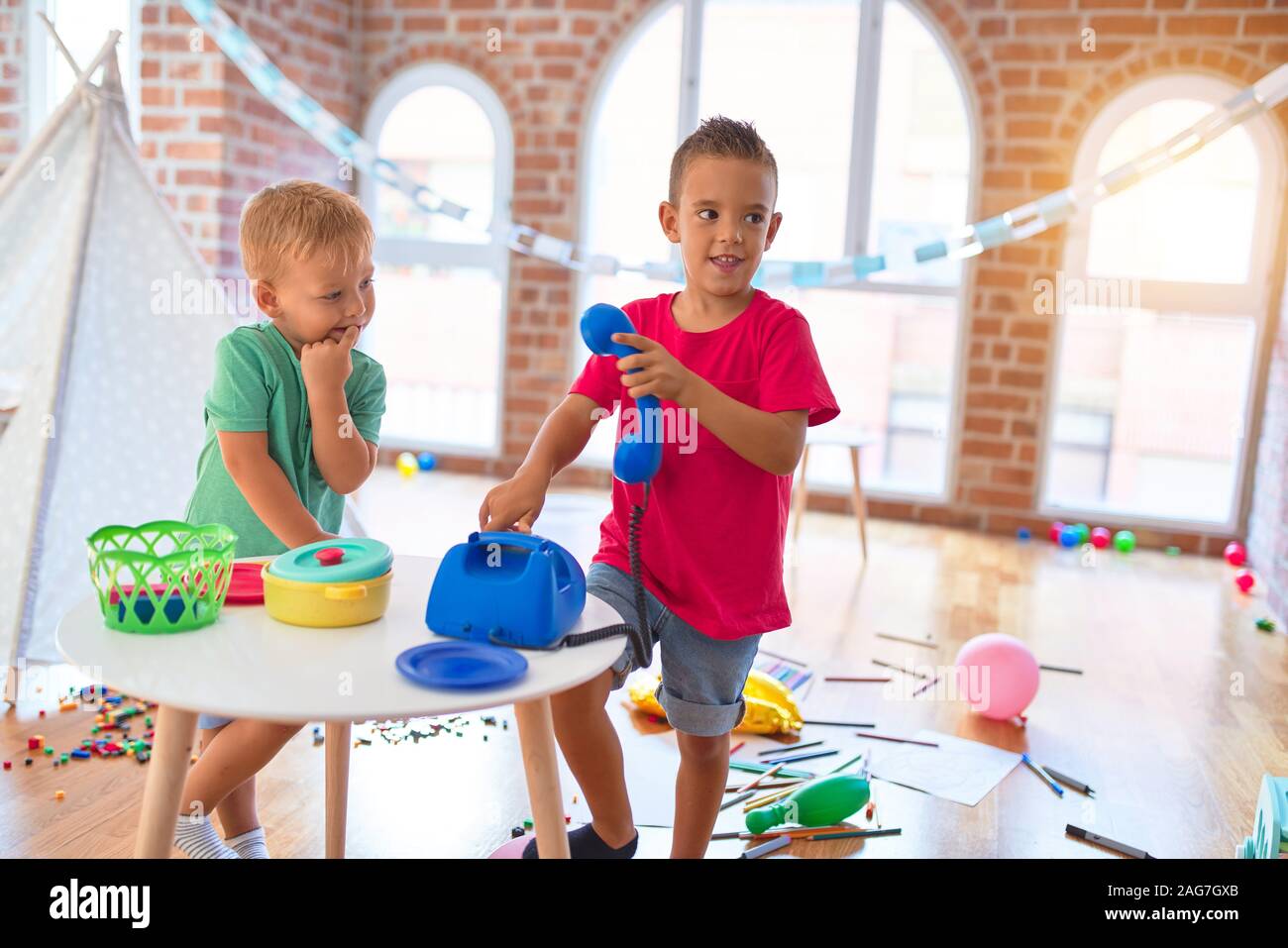 Adorable toddlers playing around lots of toys at kindergarten Stock ...