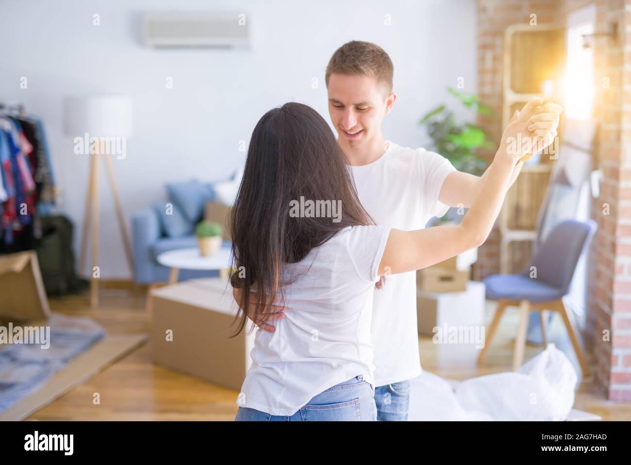 Young beautiful couple dancing at new home around cardboard boxes Stock ...