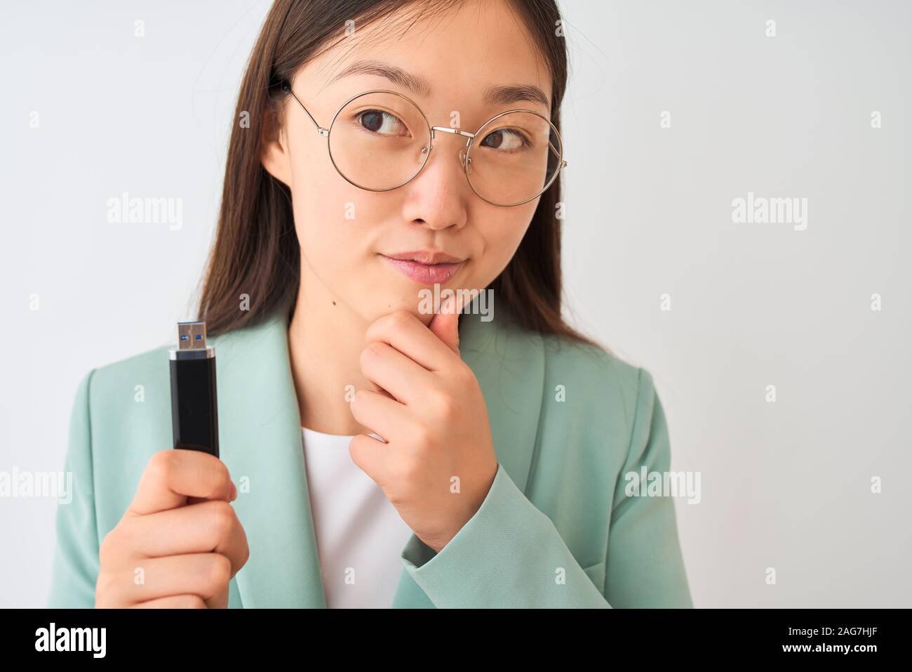Young chinese businesswoman holding usb memory over isolated white ...