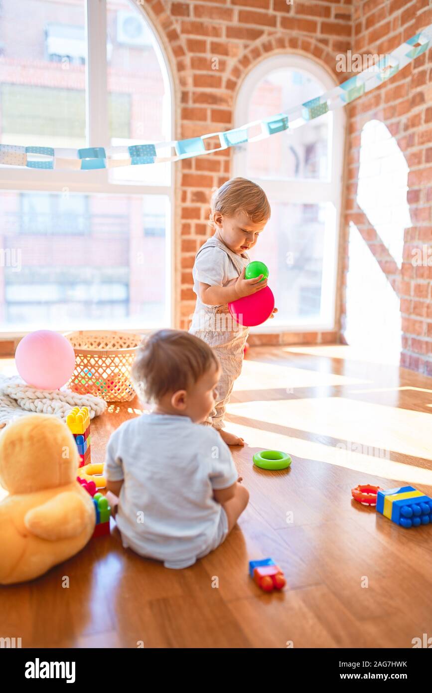 Beautiful toddlers playing around lots of toys at kindergarten Stock ...