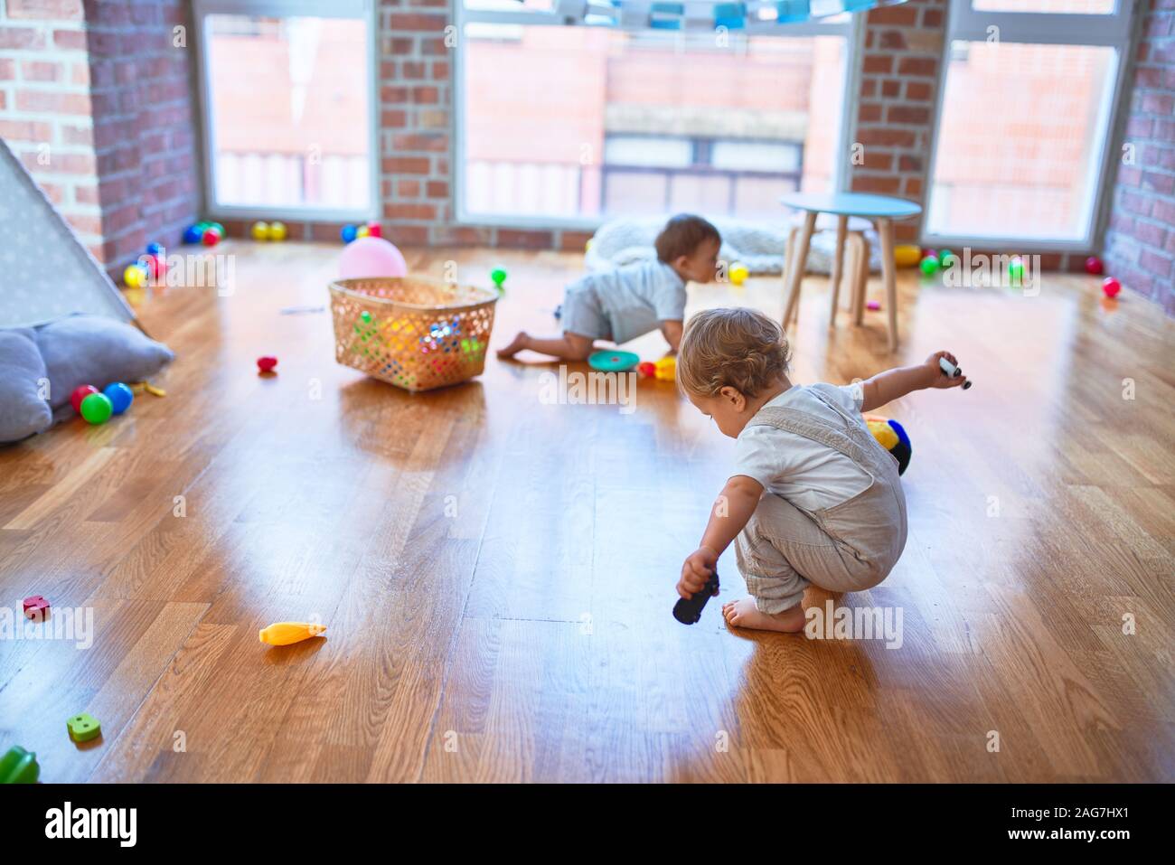 Beautiful toddlers playing around lots of toys at kindergarten Stock ...