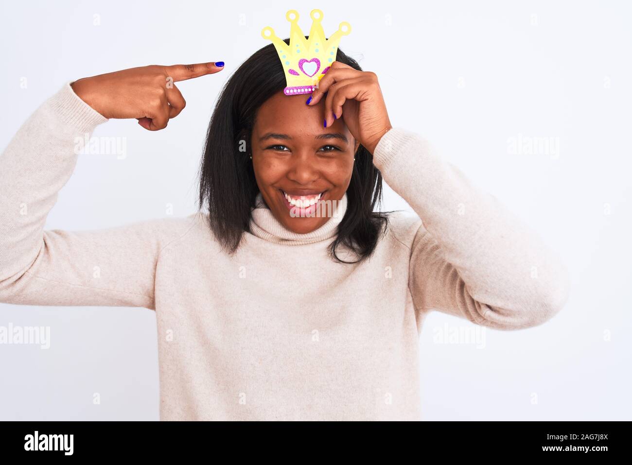 Young african american woman wearing pretend queen crown over isolated ...